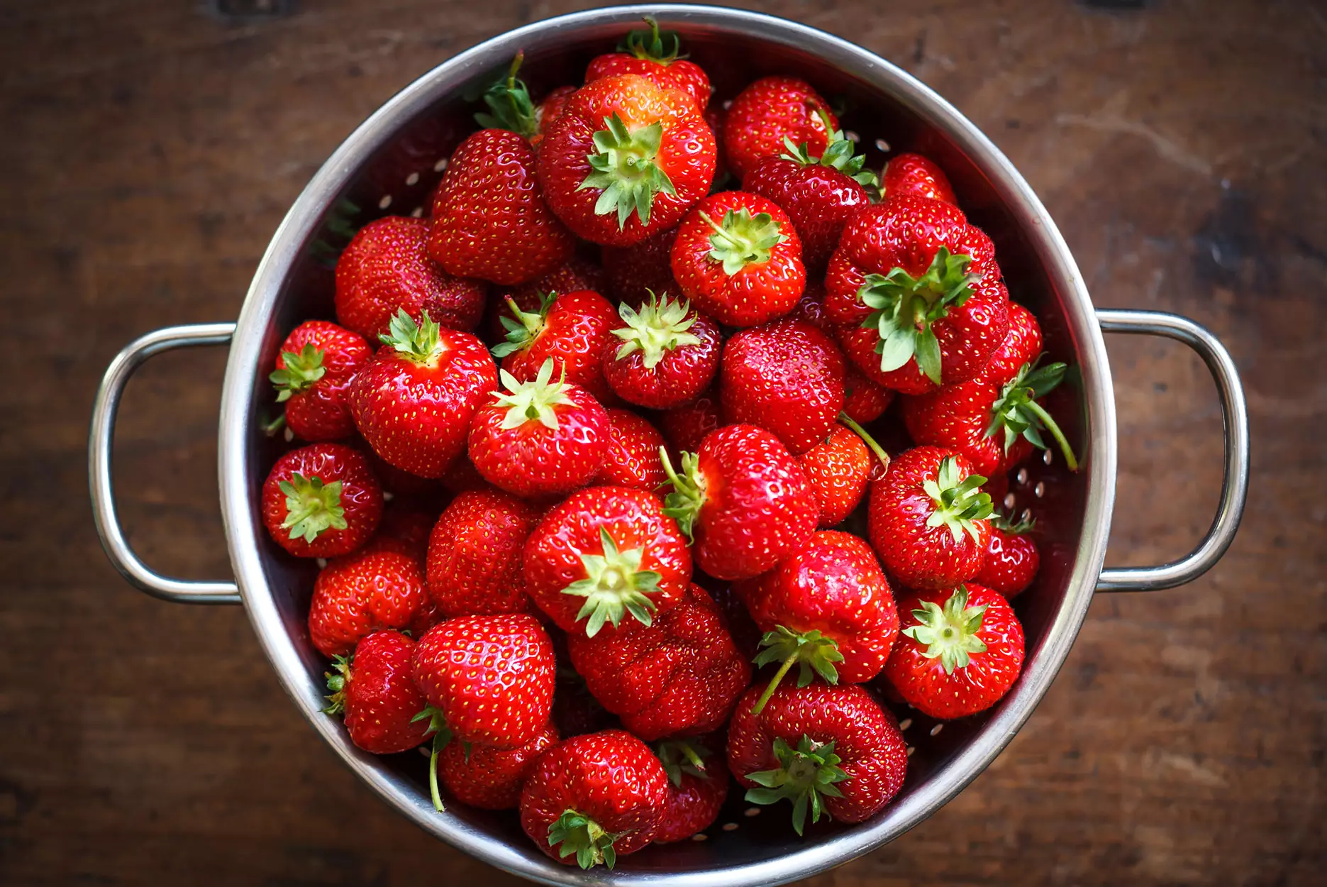 Colander penuh dengan strawberi masak