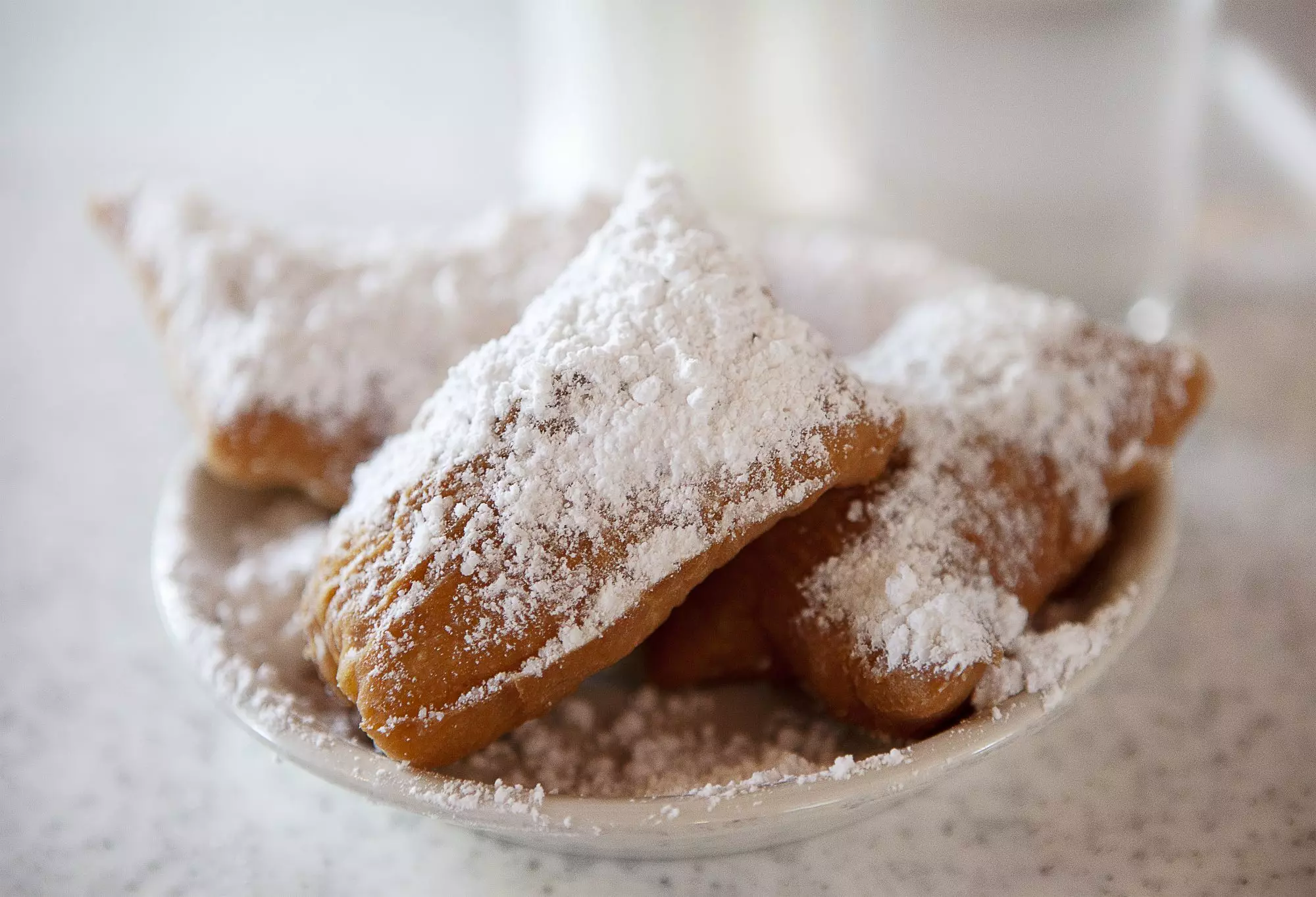 Beignets s moučkovým cukrem na talíři