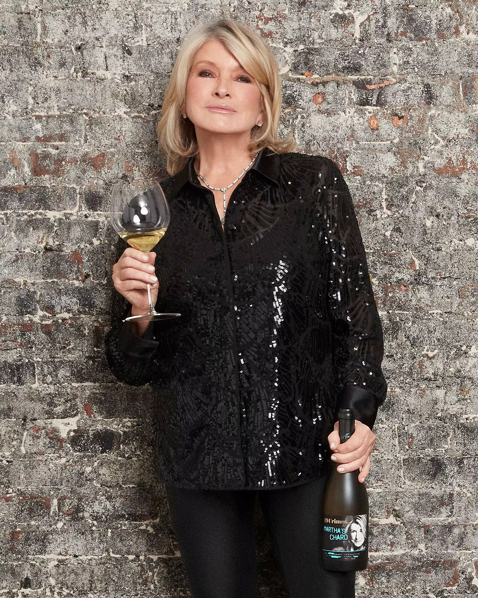 Martha Stewart pozuoja su taure ir buteliuku „19 Crimes Martha Chard“.