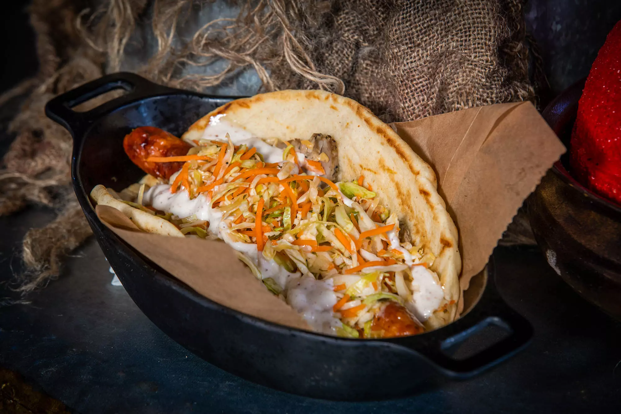 Ronto Wrap kun kradita porkkolbaso sur pita pano sur ekrano ĉe la Ronto Rostilo dum amaskomunikiloj ricevas antaŭprezenton dum la evento de Star Wars: Galaxy's Edge Media Preview ĉe la Disneyland Resort.