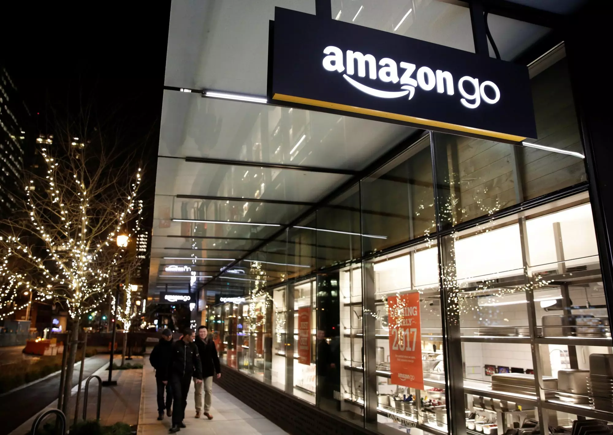 Ndị mmadụ na-aga n'akụkụ ụlọ ahịa ihe nri brik na ngwa agha Amazon Go na-enweghị ahịrị ma ọ bụ ọnụ ahịa nlele, na Seattle Washington