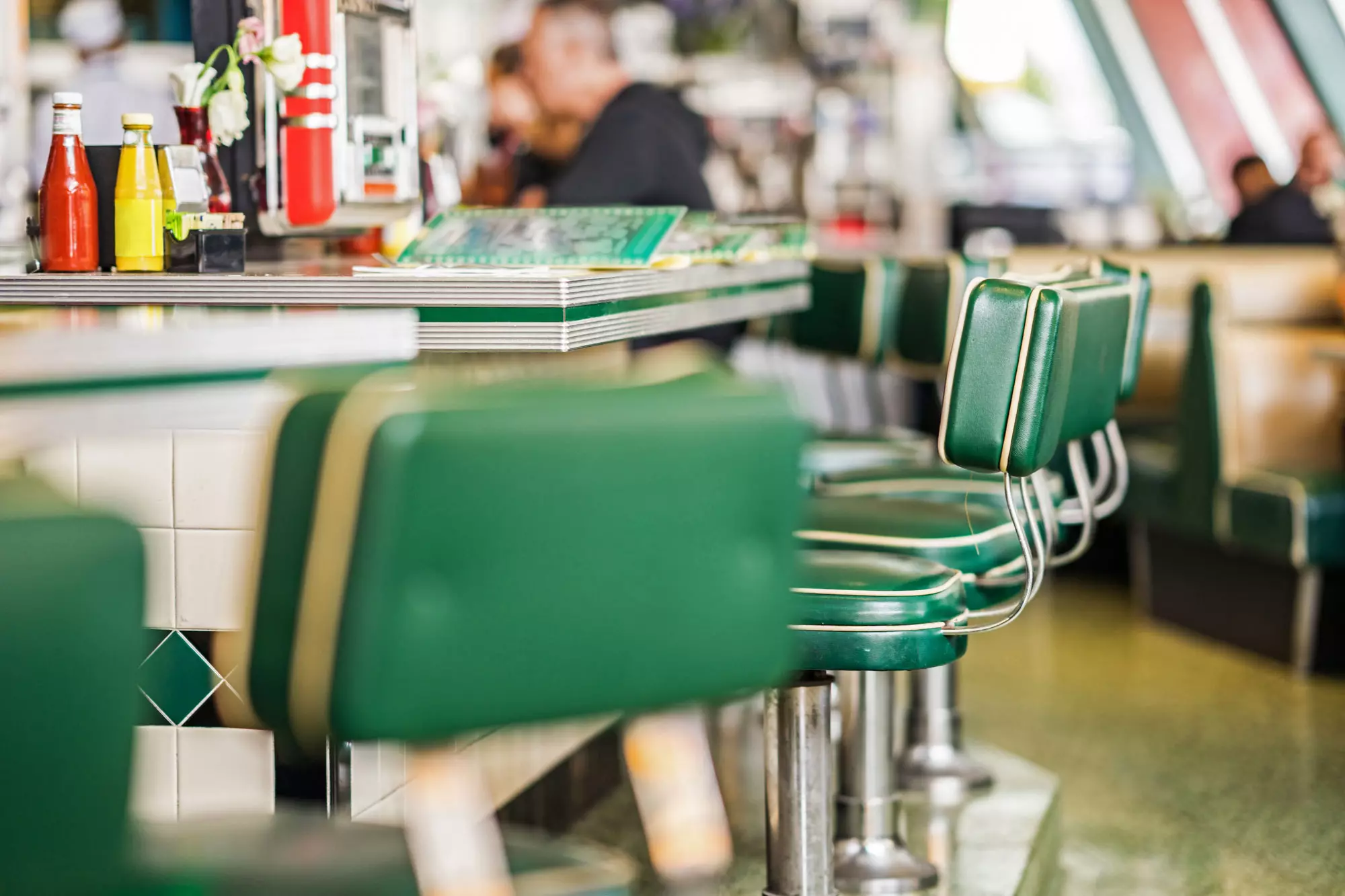 Detalhes de couro cromado e verde em um restaurante retrô drive-in