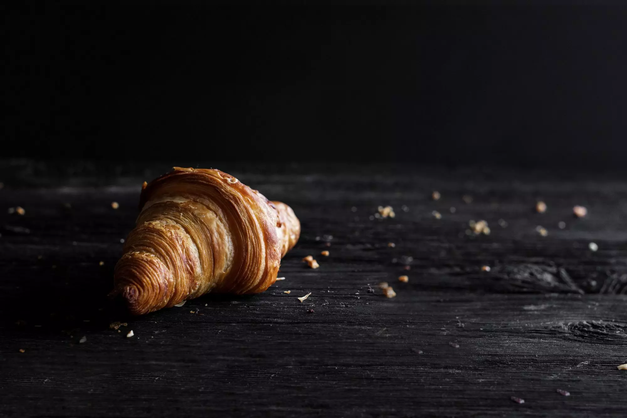 Croissant op houten eftergrûn