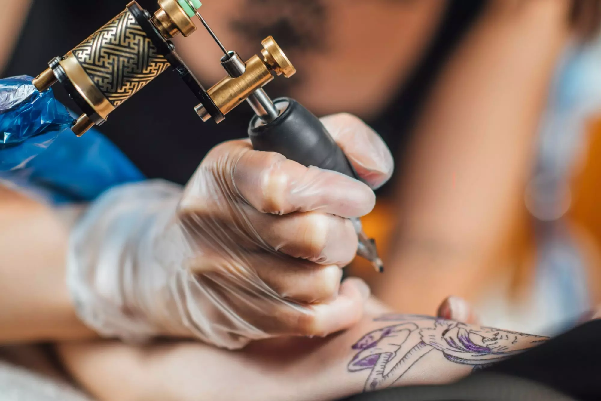 Tattoo Machine Close-up. Tatoeëerder maakt tatoeage op de arm van een man